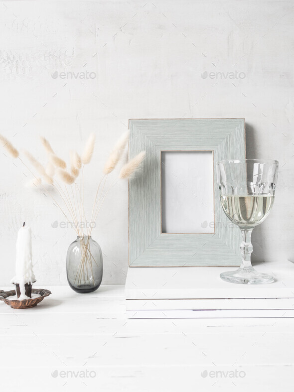Modern feminine still life of glass of white wine and various items ...