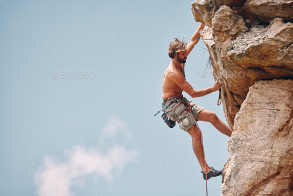 Man mountain or rock climbing while cliff hanging and adrenaline ...