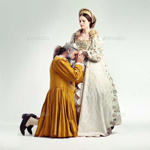 A royal promise. Studio shot of a king kneeling and kissing his queens ...