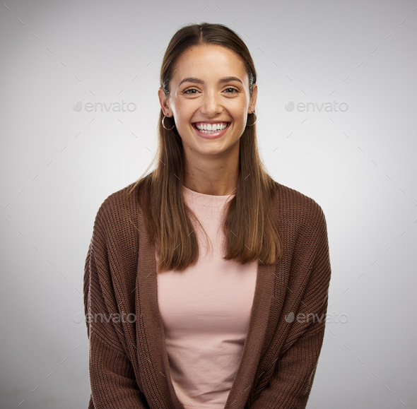 Smile a while. Studio shot of a beautiful young woman posing against a ...