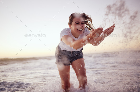 Splash, ocean and woman at the beach in the water, enjoying the waves ...