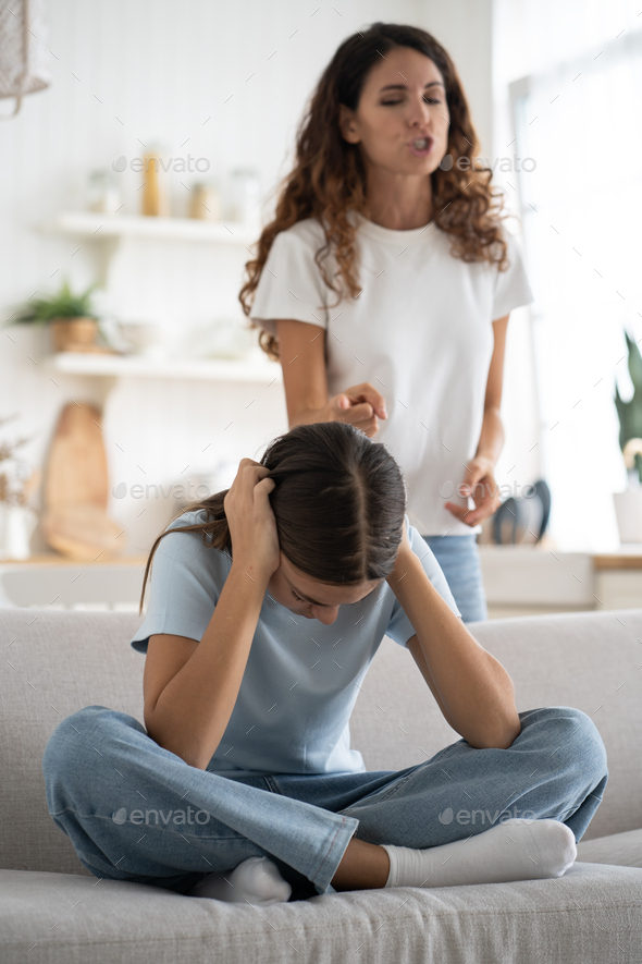 Depressed teen girl covering ears not to listen angry furious mother ...