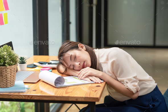 Overwork of young Asian businesswoman makes her tired and asleep at the ...