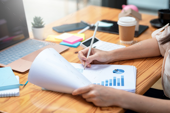businesswoman hand holding a pencil analyzing a graph goals statistics ...