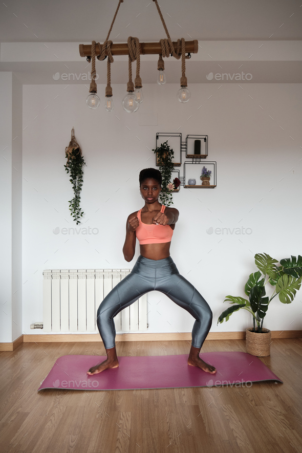 Fit black female athlete in process of doing Goddess pose Stock Photo ...
