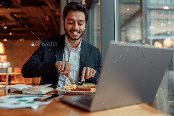Indian businessman eating lunch during break after work in cafe Stock ...