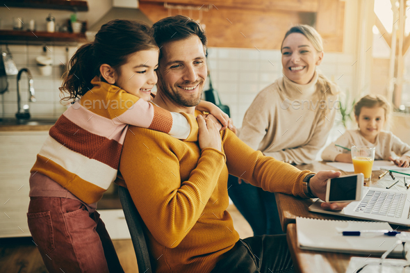 Happy working father and his daughter embracing at home. Stock Photo by ...
