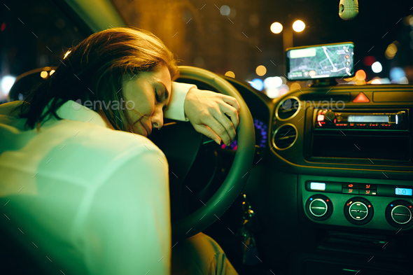Sad woman crying behind steering wheel in a car at night. Stock Photo ...