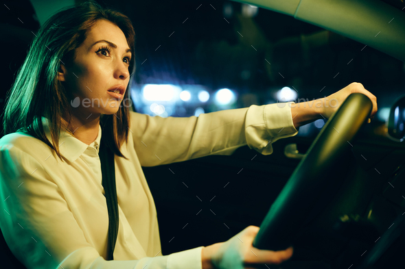 Young sad woman crying while driving alone in a car at night. Stock ...