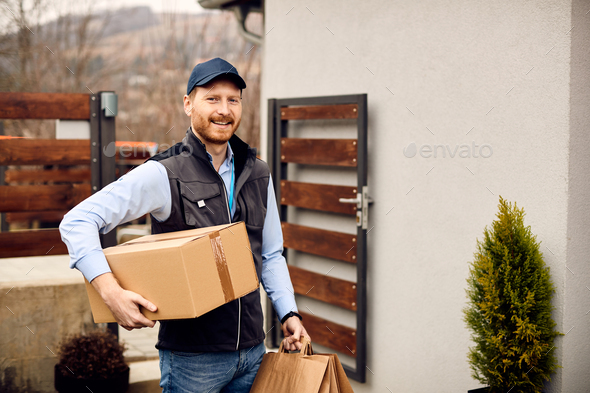Portrait of happy delivery man at work looking at camera. Stock Photo ...