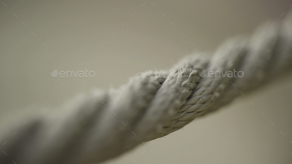 Extreme close up of a rope on blurred beige background. Action. Macro ...