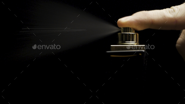 Perfume bottle with male finger on black background. Man applying ...