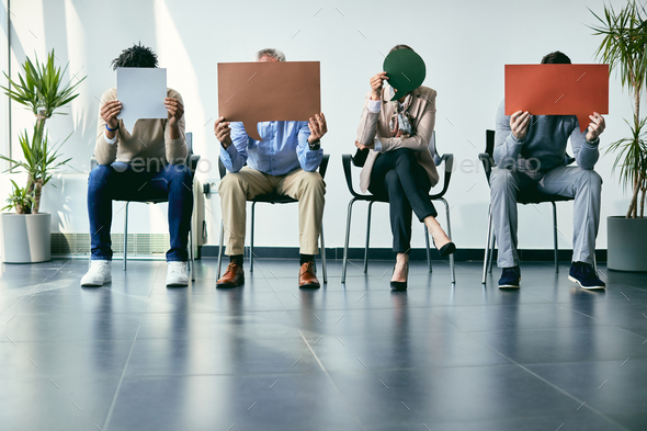 Business people holding up speech bubbles in front of their faces while ...