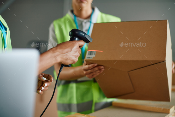 Close up of workers preparing packages for shipment and scanning labels ...