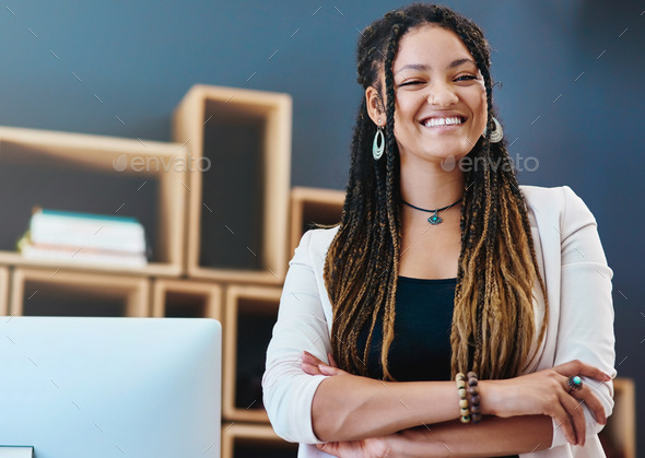 Cropped portrait of an attractive young woman standing with her arms crossed in her home office ...