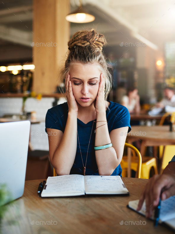 Cropped shot of a young student looking stressed while studying in a ...