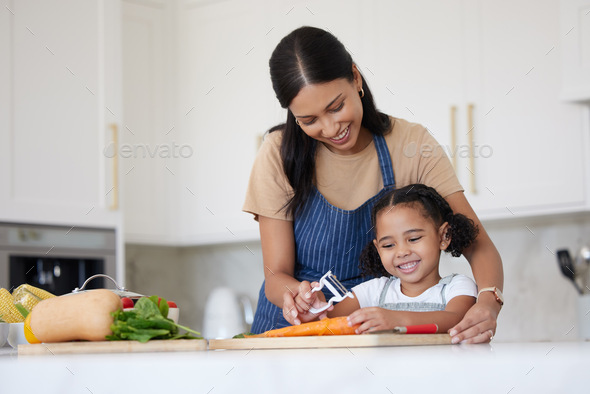 Caring mother and adorable daughter cooking and bonding at home. Happy ...