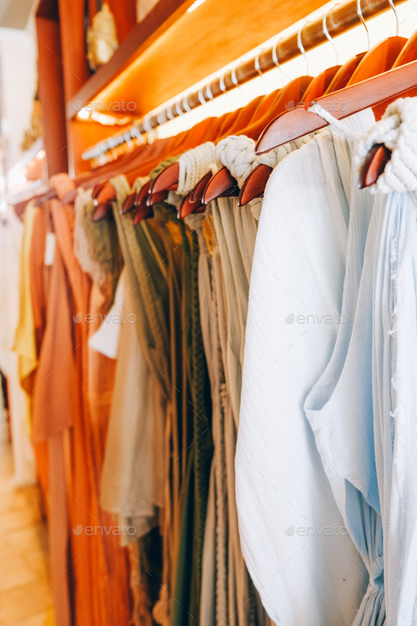 Rack with stylish different women's linen clothes indoors in fashion ...