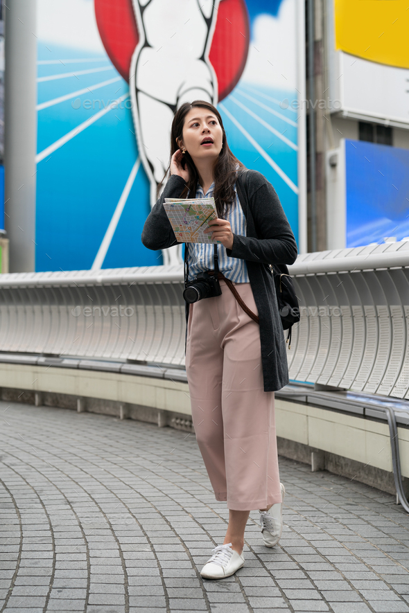 lost girl with map near glico man sign Stock Photo by primagefactory