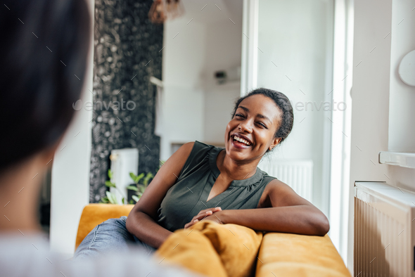 Adult African woman, socializing with her friends. Stock Photo by bnenin