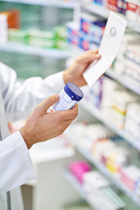 Making sure he gets all the right medication. A pharmacist reading a ...