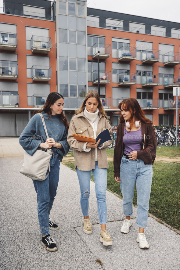 Vertical photo of three young woman standing outside in front of their ...