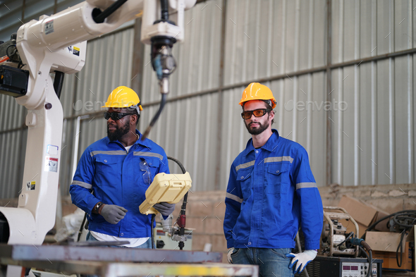 Robotics engineer operating robot aided CNC machine in robotics ...