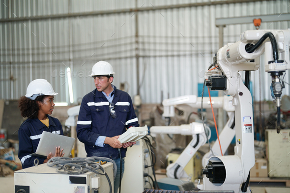 Robotics engineer operating robot aided CNC machine in robotics ...