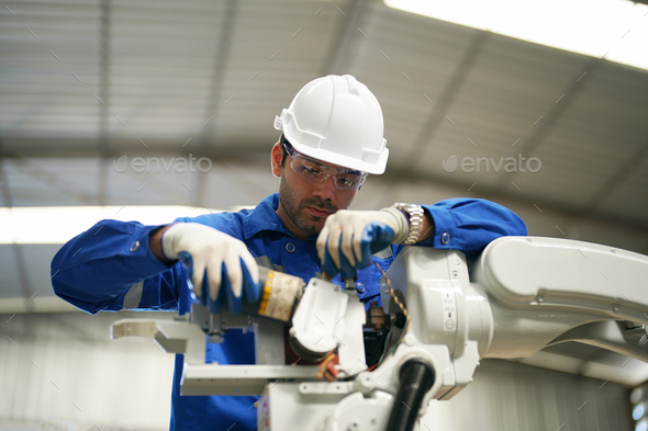 Robotics engineer operating robot aided CNC machine in robotics ...