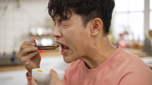 male making funny face tasting spicy food Stock Photo by primagefactory