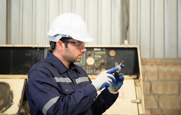 The chief mechanic works in a mechanical factory. Stock Photo by wosunan