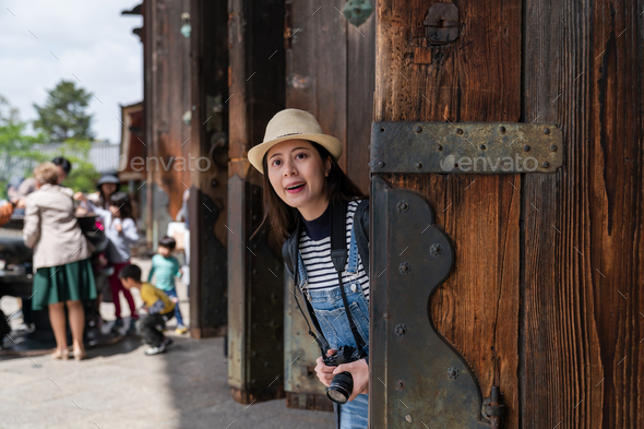 female popping head out from wood gate at todaiji Stock Photo by ...