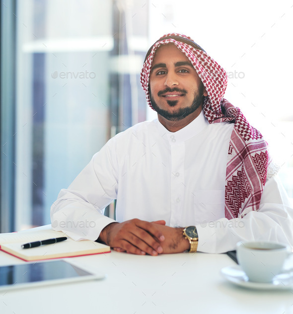 Portrait of a confident young muslim businessman working at his desk in ...