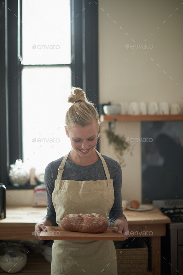 The perfect loaf. Shot of a young female baker with homemade bread ...