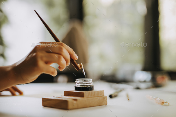 Artist holding old-fashioned fountain pen for calligraphy writing ...