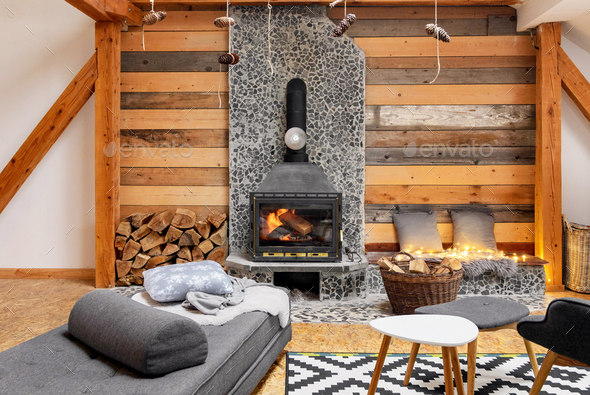 Cozy cabin interior with a burning fireplace Stock Photo by wirestock