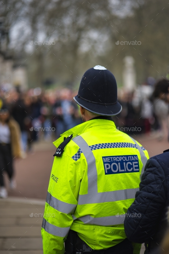 Vertical shot of a police officer in front of the historic Buckingham ...