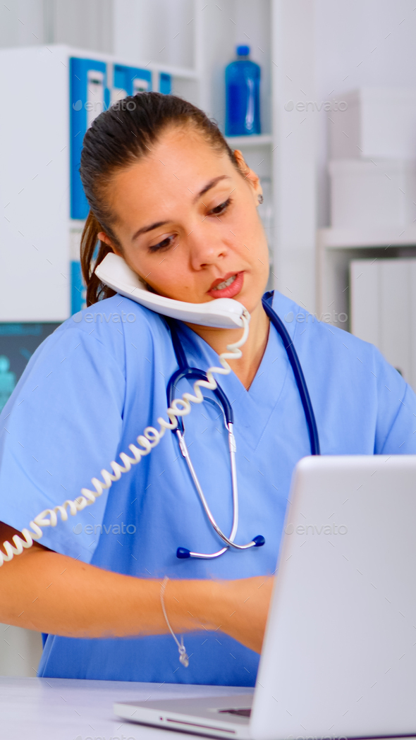 Medical assistant speaking at phone with patient analysing x-rays Stock ...