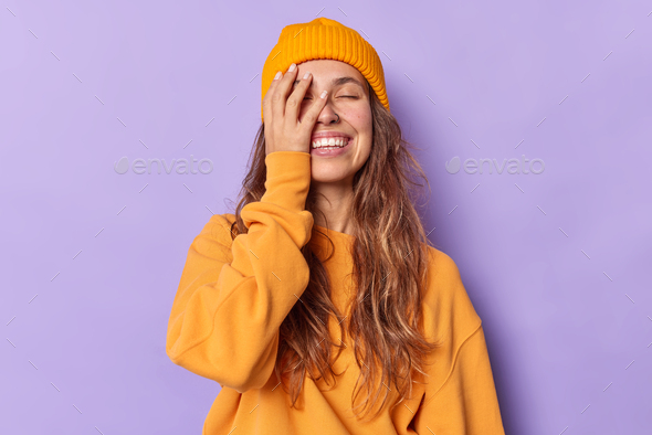 Positive sincere millennial girl has long hair makes face palm keeps ...