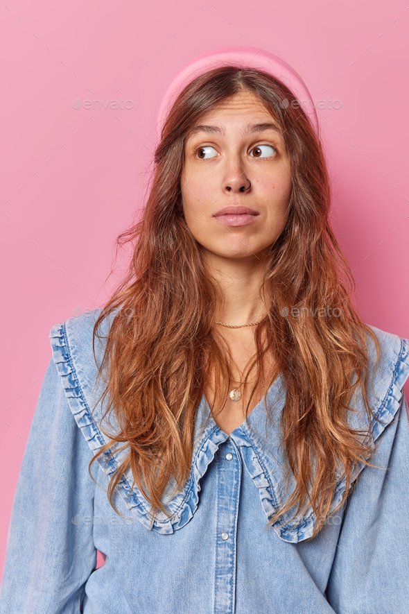 Vertical shot of surprised Caucasian woman looks away with wonder ...