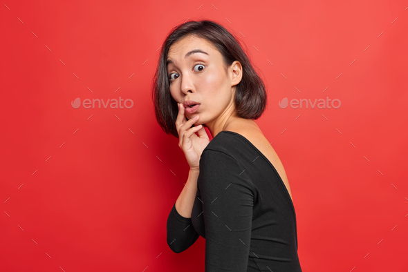 Sideways shot of good looking woman with dark hair dressed in black ...