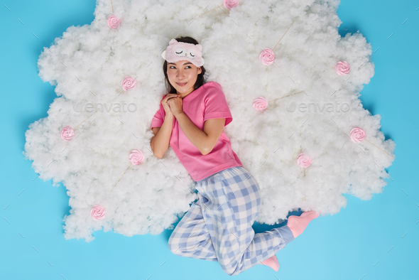 Overhead shot of dreamy young Asian woman dressed in pajama has healthy ...