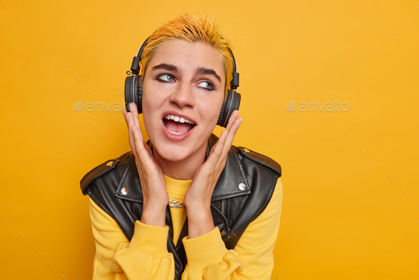Optimistic teenager with makeup short yellow hair wears black leather ...