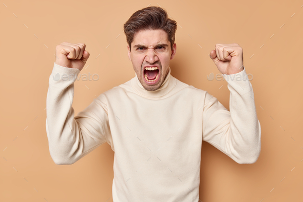 Furious outraged man clenches fists gestures angrily shows anger and ...