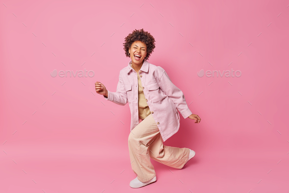 Horizontal shot of joyful young woman has overjoyed expression rejoices ...