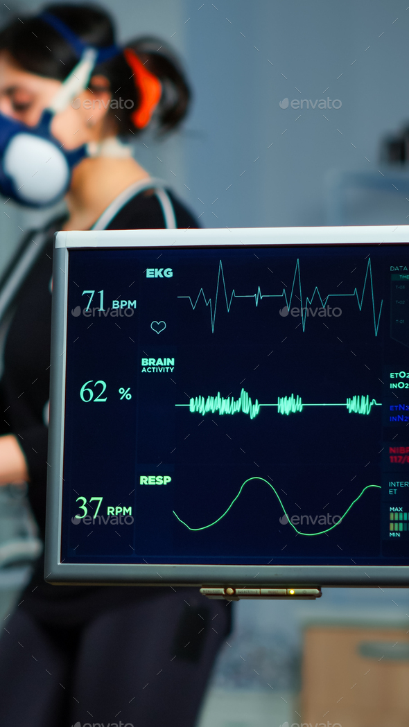 Monitor showing EKG scan of athlete running on cross trainer Stock ...