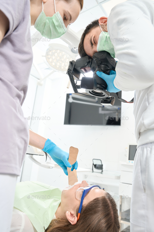 Stomatologist taking photos of client teeth before primary examination ...