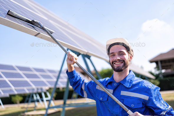 Service engineer use a mop cleaning solar panel for good performance ...