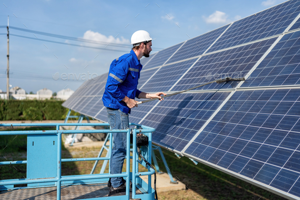 Service engineer use a mop cleaning solar panel for good performance ...