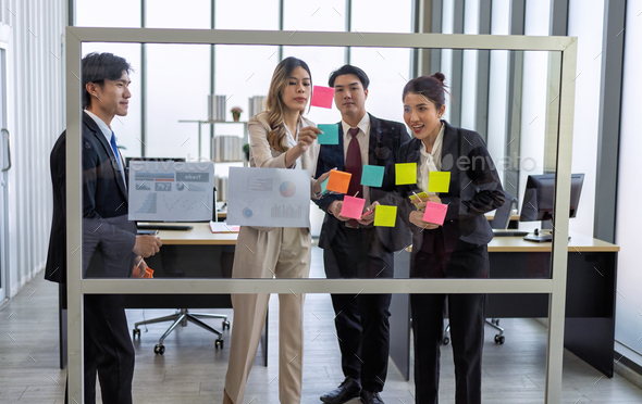 Employee meeting at office and use post it notes to share idea ...